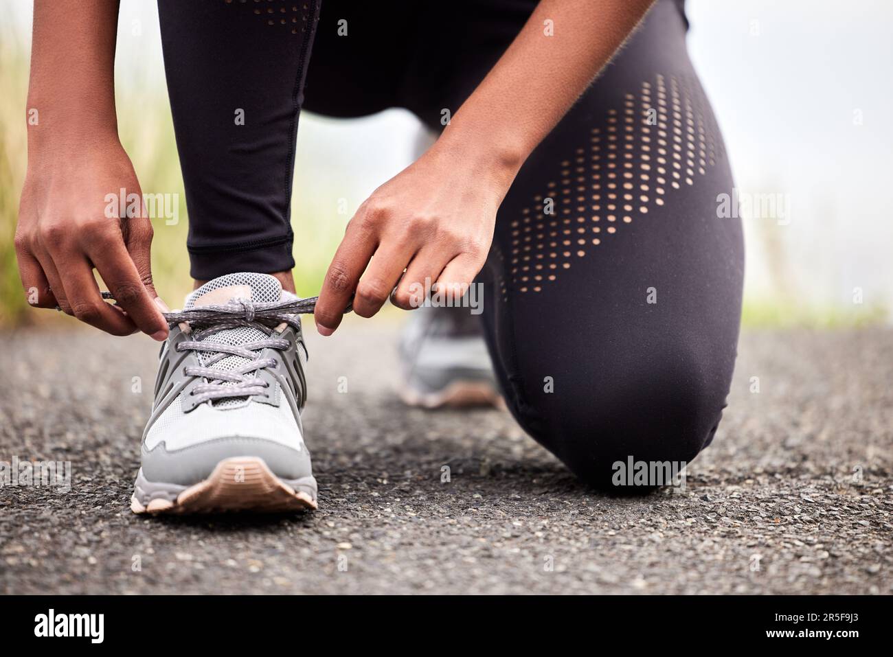 Fitness, feet of woman tying shoes and runner on road for safety during ...