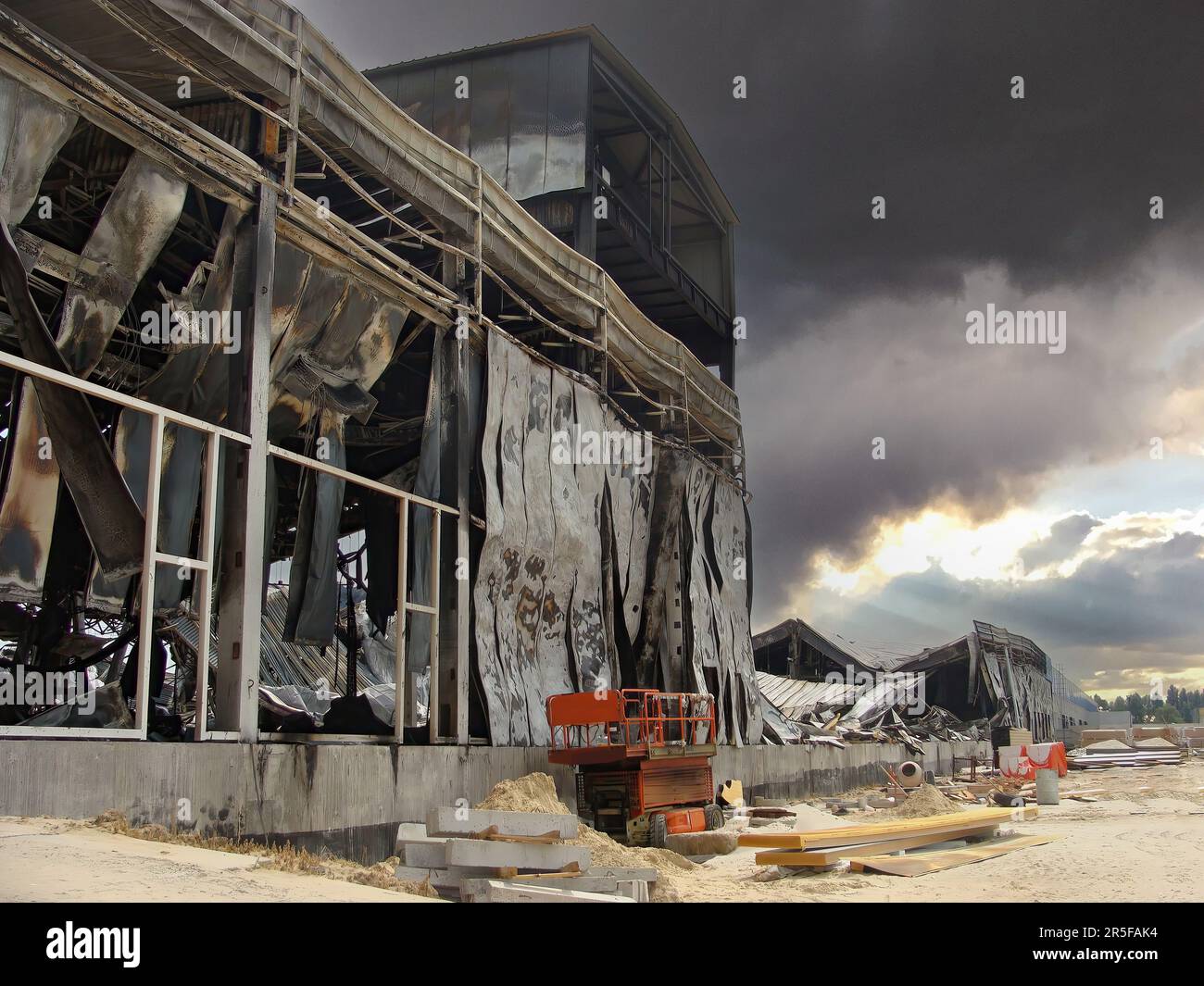 The aftermath of a warehouse fire, charred and destroyed structures ...