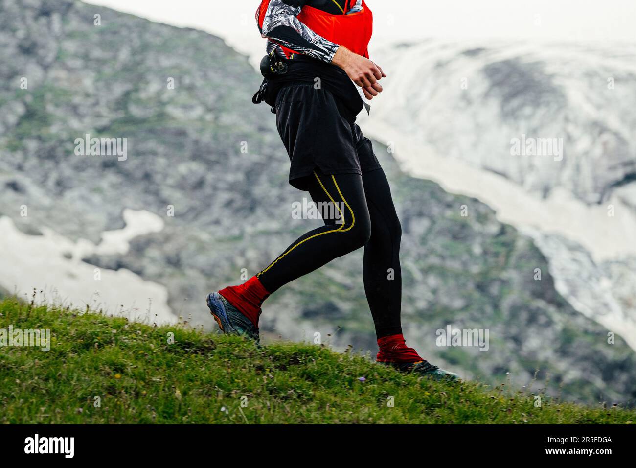legs male runner running down mountain marathon race on green meadow ...