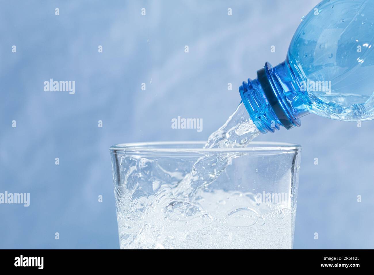 Fresh and cool water flows from the neck of the bottle. Water is poured ...
