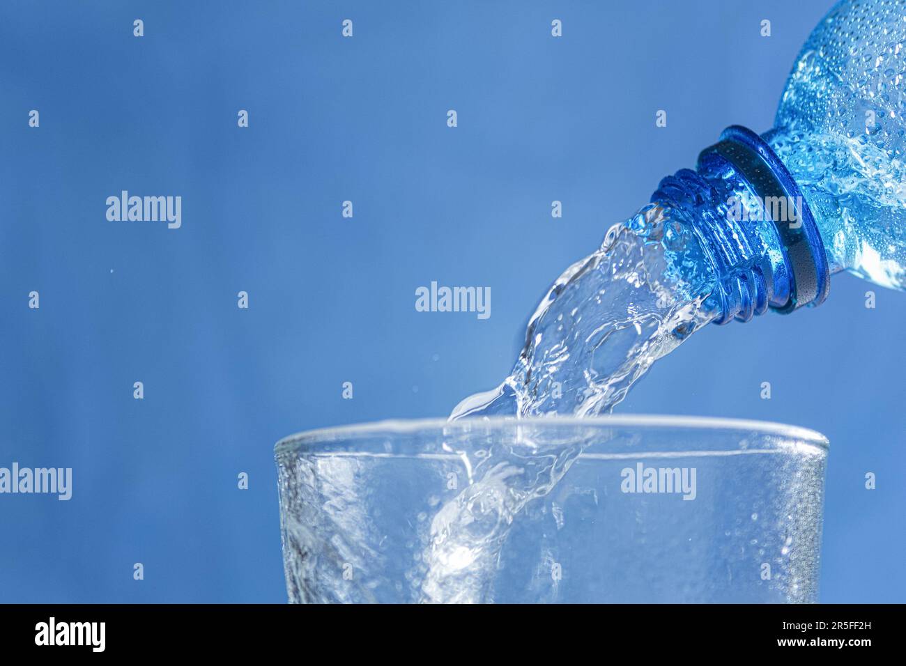 Fresh and cool water flows from the neck of the bottle. Water is poured ...