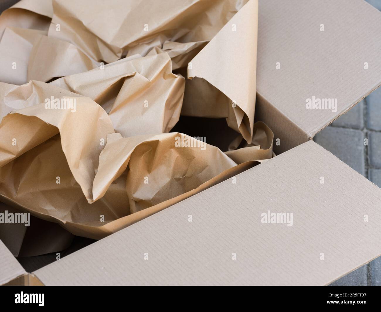 Crumpled paper in a cardboard box. Close up Stock Photo - Alamy