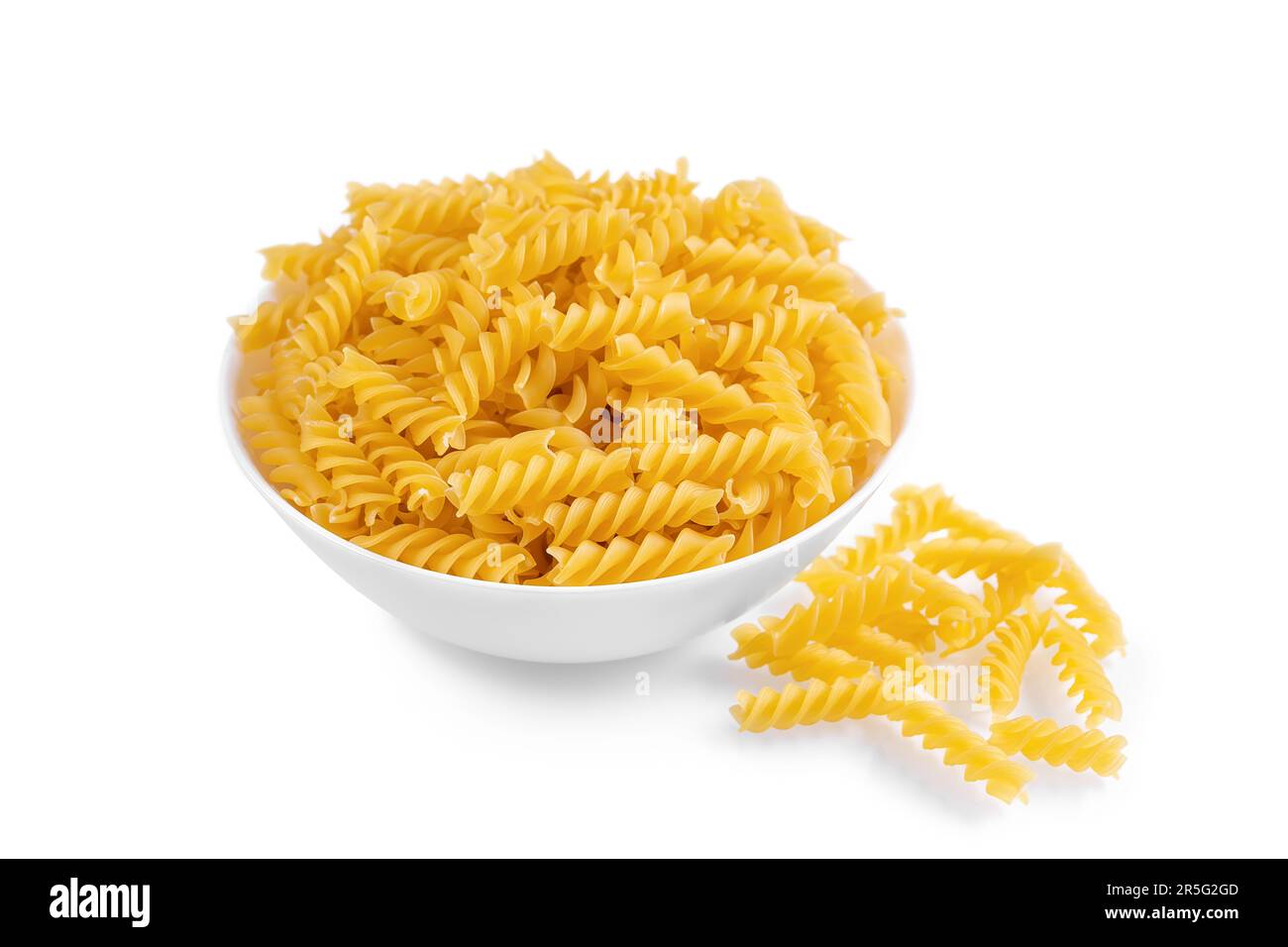 Fusilli in bowl and isolated on white background. Raw pasta spiral ...