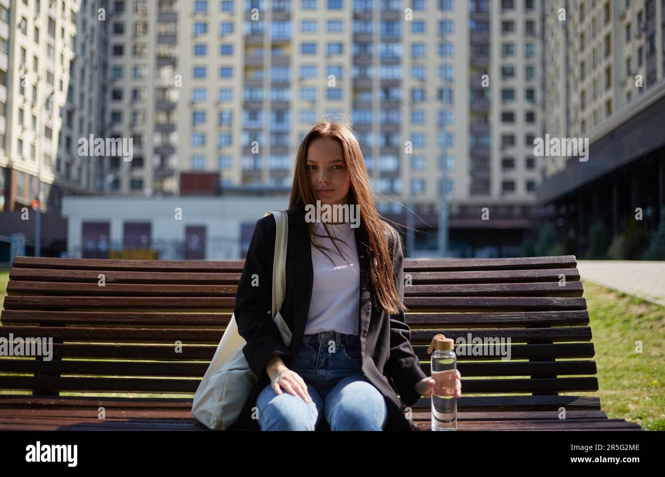 Beautiful Ukrainian female with long brown hair sitting on a bench in ...