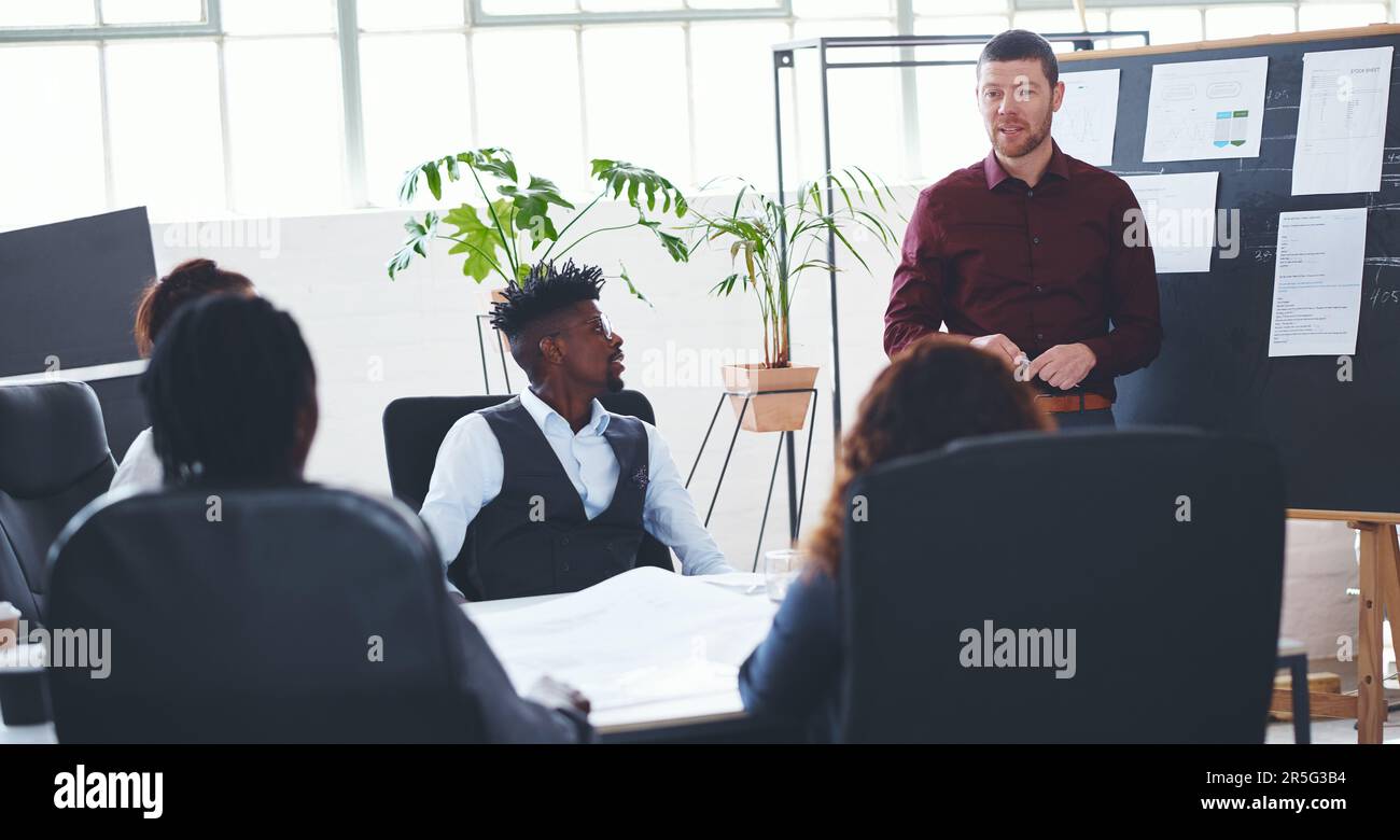 Presenting the master plan hes been working on. a businessman giving a ...