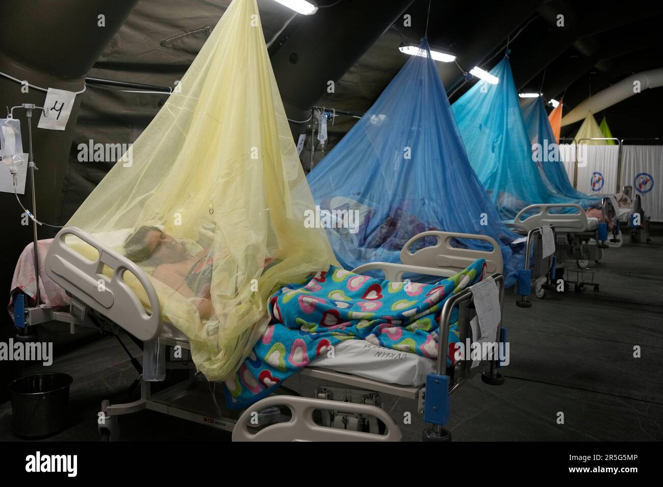 Patients suffering from dengue lie in beds in provisional tents at the ...