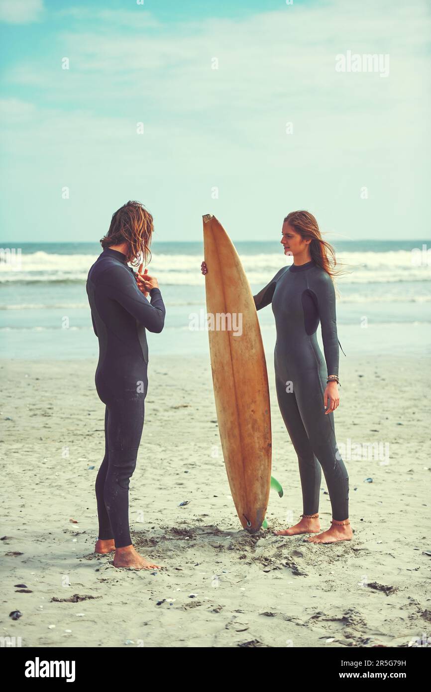 The perfect day with the perfect person. a young couple surfing at the ...