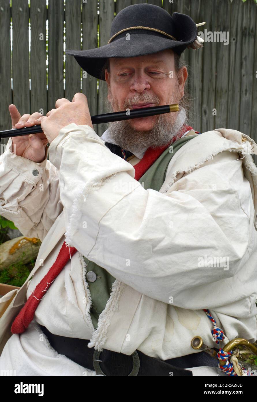 A 19th century pioneer reenactor talks with visitors while ...