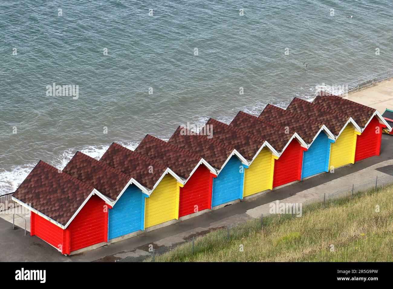 A row of colourful beach huts along the promenade at Whitby, taken from ...