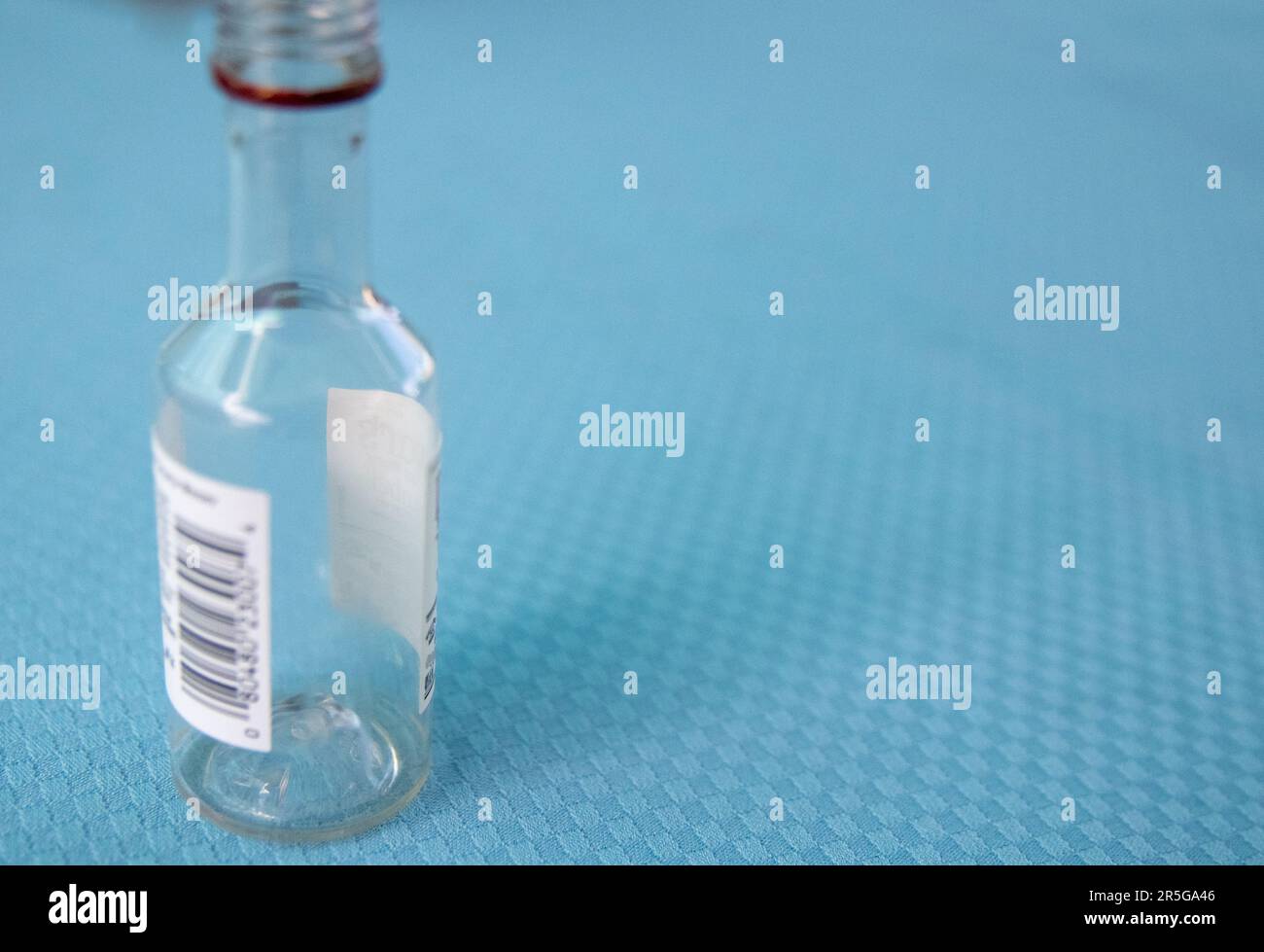 An empty alcohol bottle on a table Stock Photo - Alamy