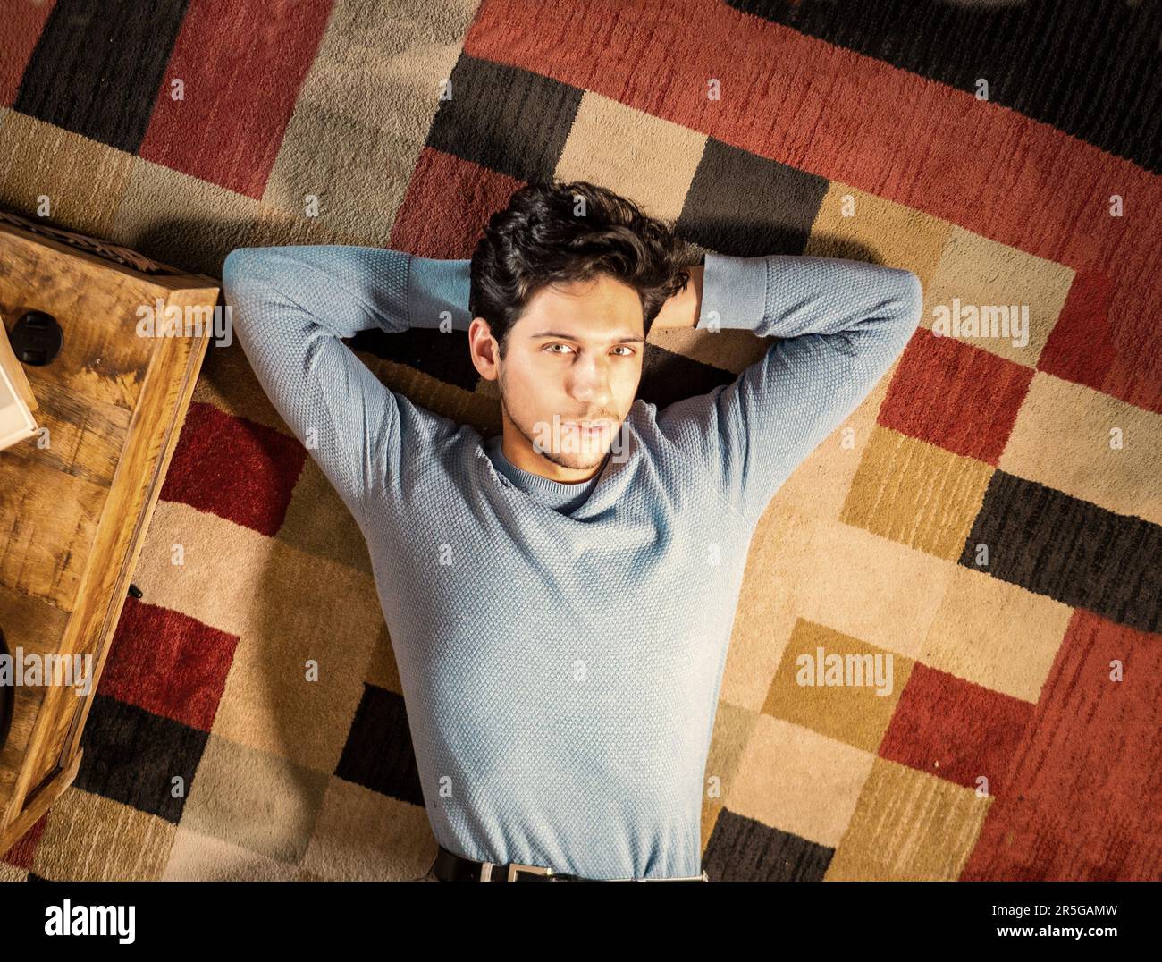 Cool dark-haired handsome young man laying on the floor Stock Photo - Alamy