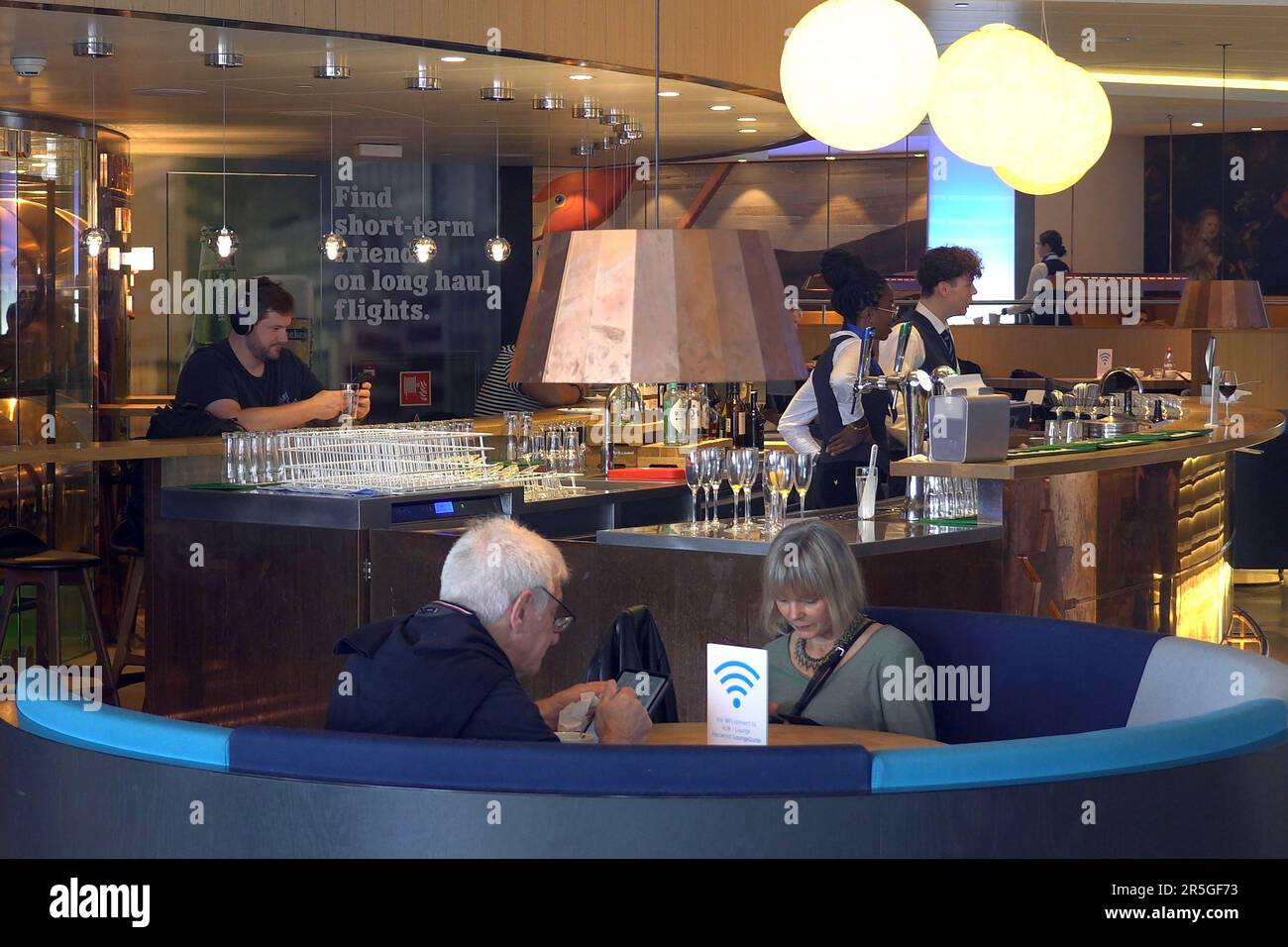 Passengers use WiFi access at the bar as they wait for their flight at ...