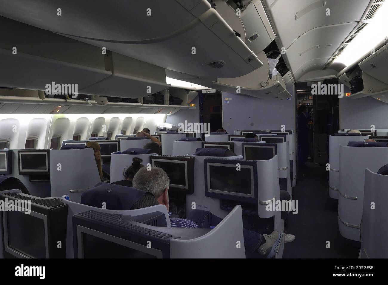 Passengers sit at the Business class cabin of Boeing 777-200 operated ...