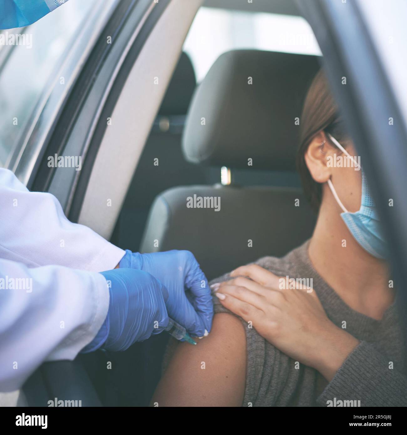 Arm yourself with proection. a masked woman receiving an injection at a ...