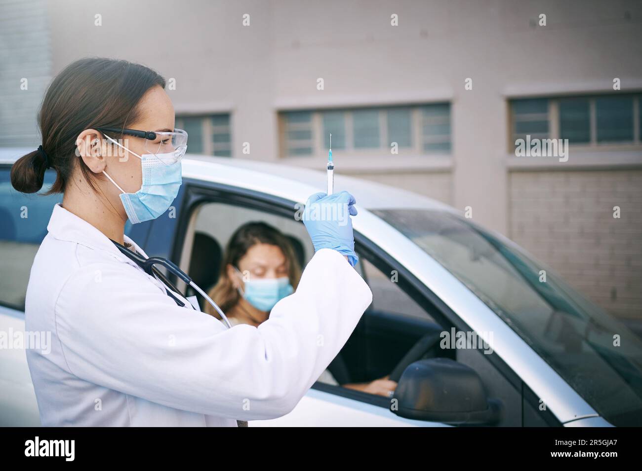 Finally the vaccine has arrived. a masked young doctor giving a patient ...