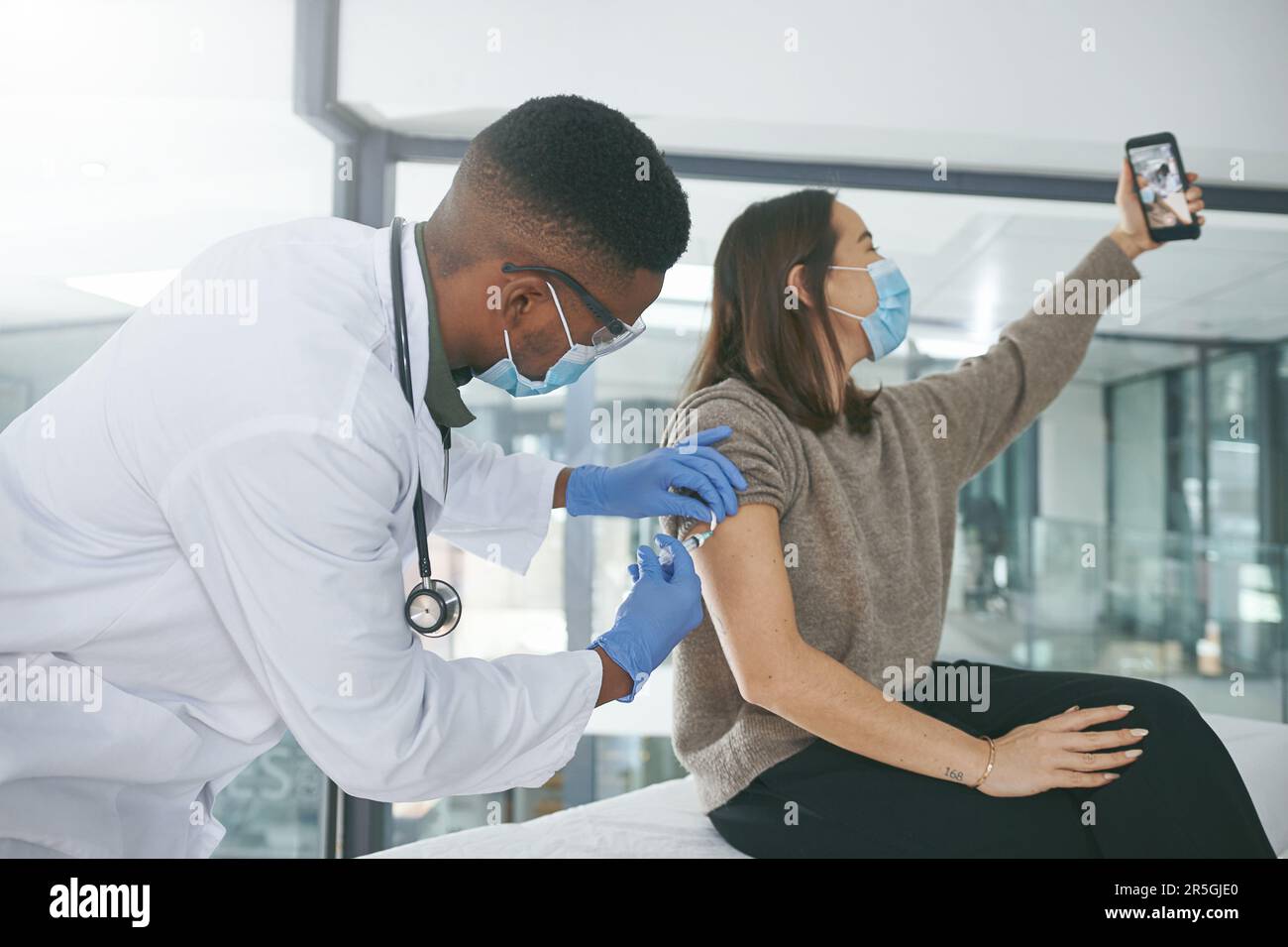 Mandatory vaccine selfie. a young doctor giving a patient an injection ...