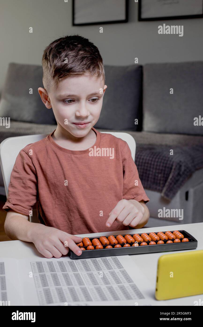 Little preschooler counting large numbers on his fingers using mental ...