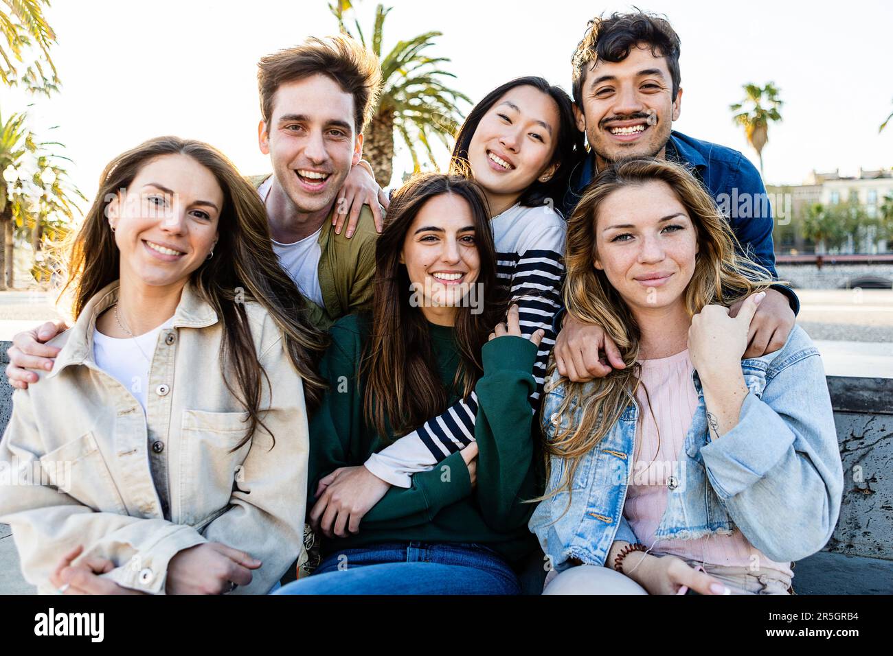 Portrait of gen z group of friends smile at camera hugging each other ...