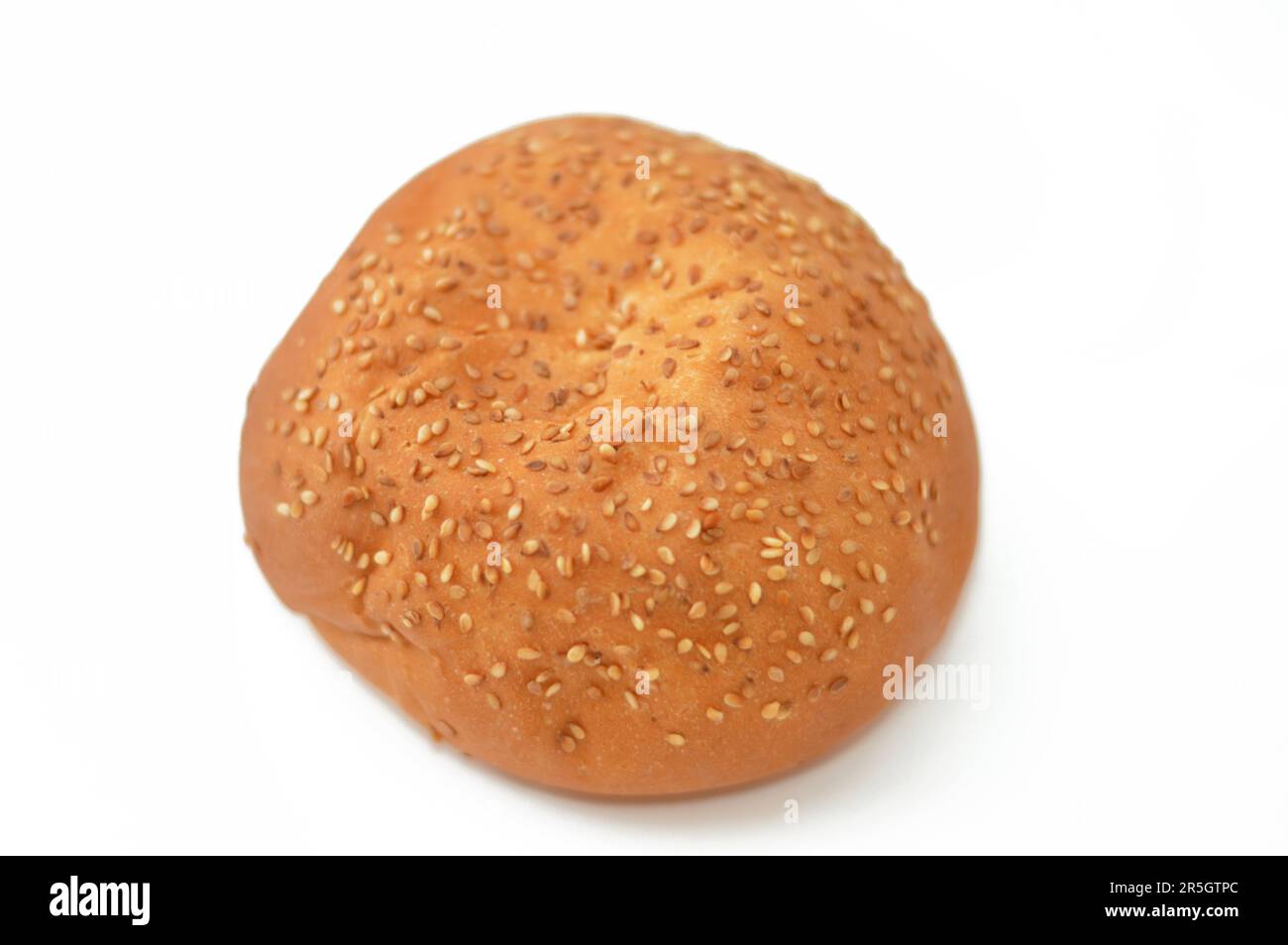 Round hand sized hamburger burger bun baked and covered with sesame ...