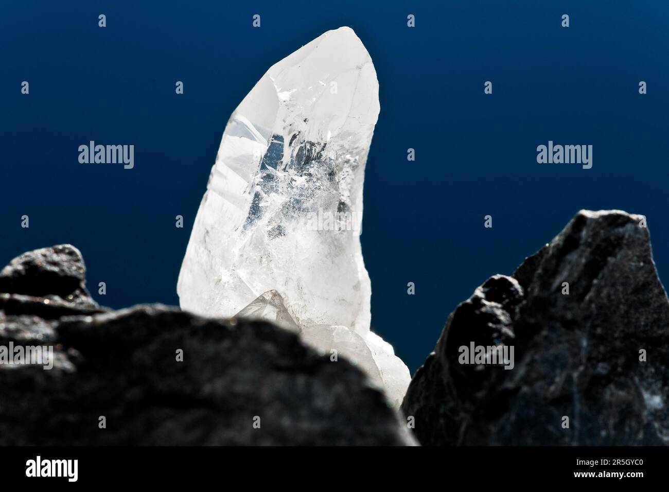 White luminous mountain crystal quartz with blue background Stock Photo ...