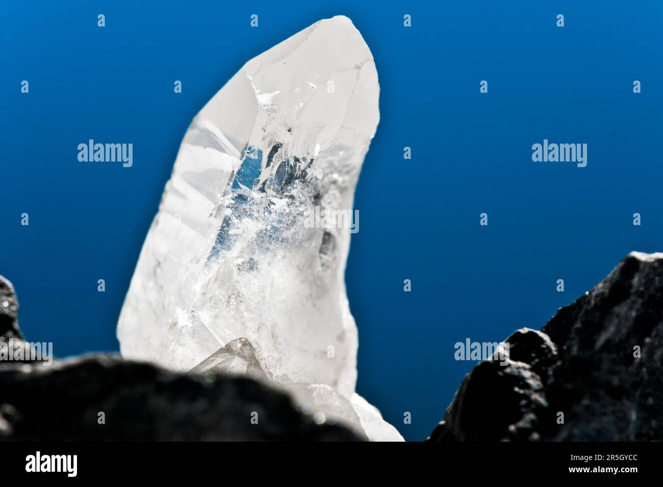 White luminous mountain crystal quartz with blue background Stock Photo ...