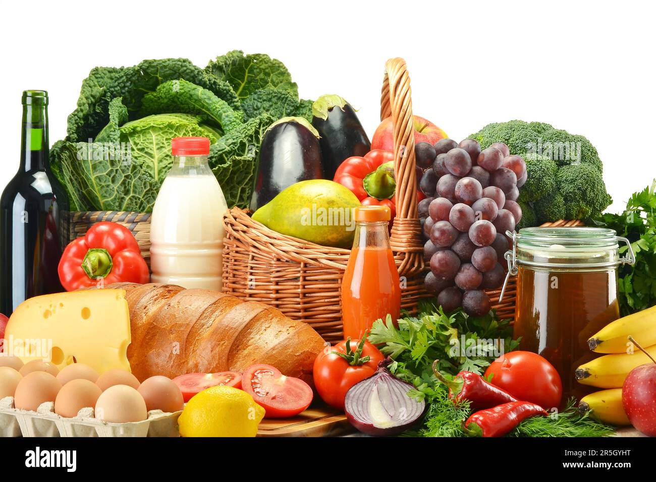 Groceries in wicker basket including vegetables, fruits, bakery and ...