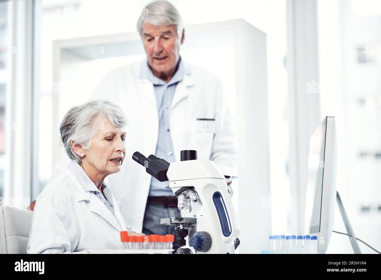 Some useful information from a coworker. two focused elderly scientists ...