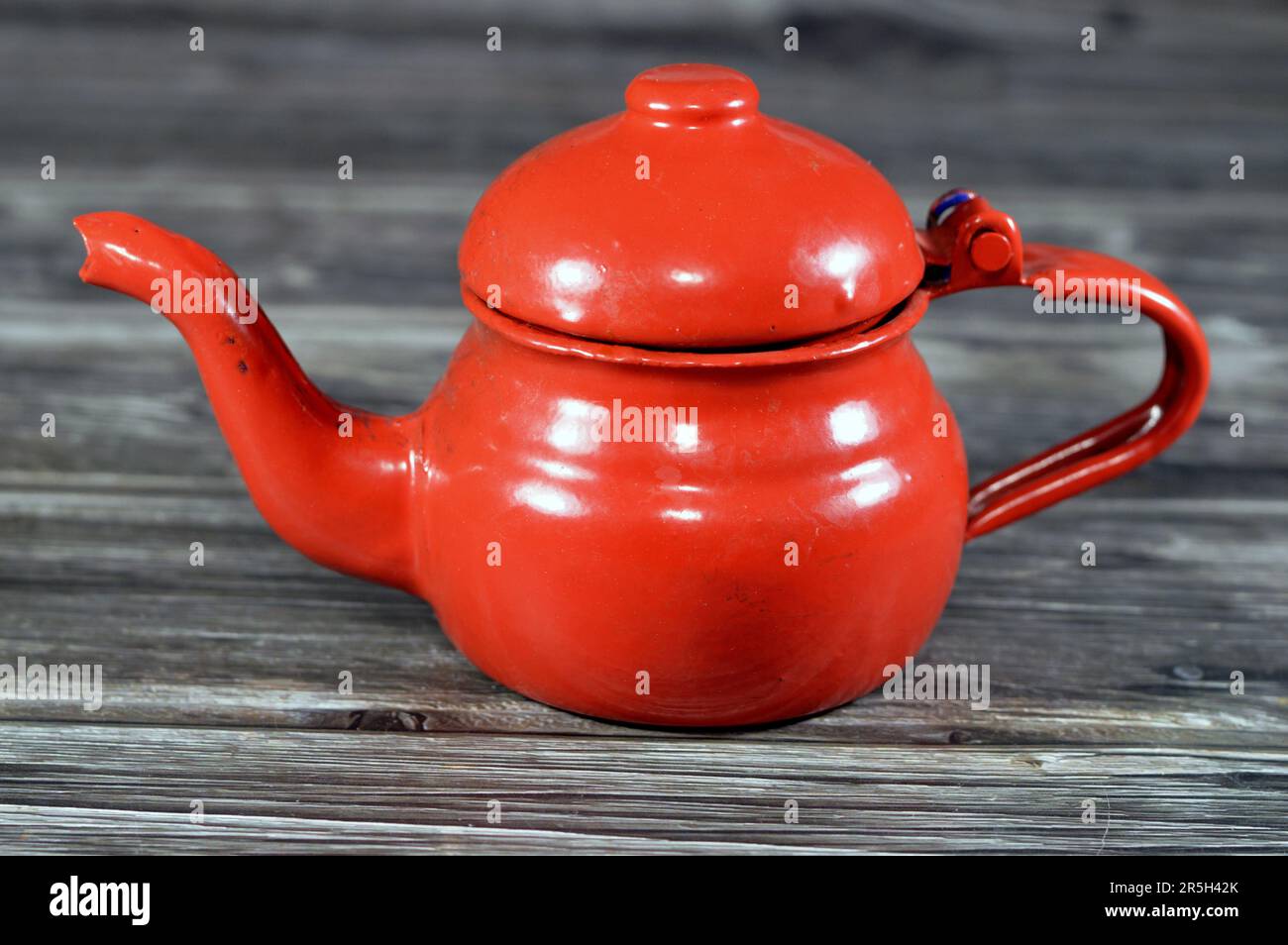 A vintage retro old style teapot, red tea pot isolated on wooden ...