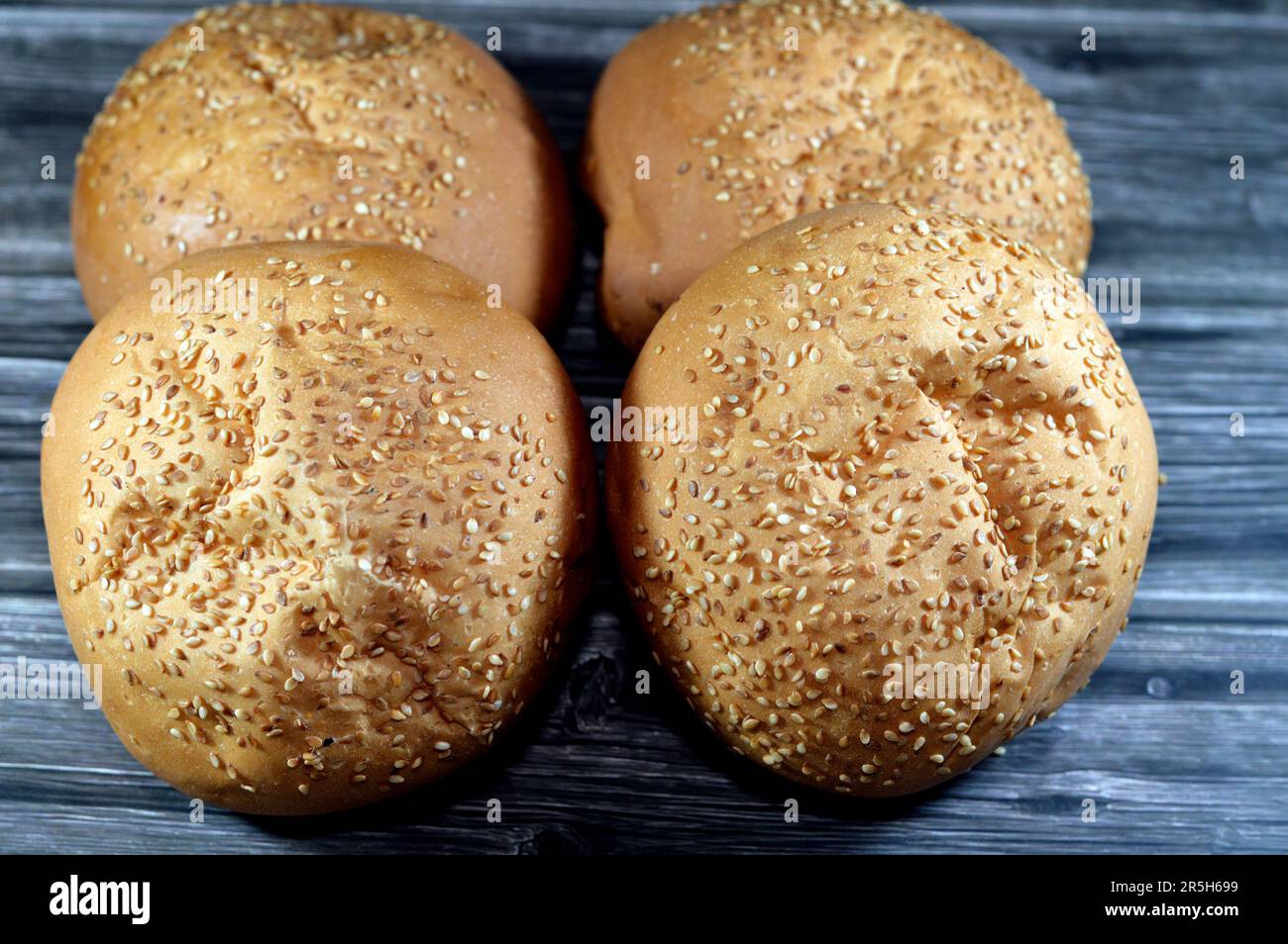 Round hand sized hamburger burger bun baked and covered with sesame ...