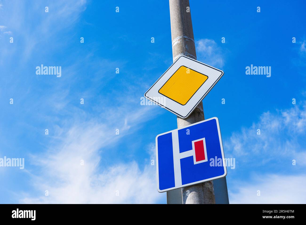 Main Road sign and a No Turn Allowed sign on a gray concrete pillar ...
