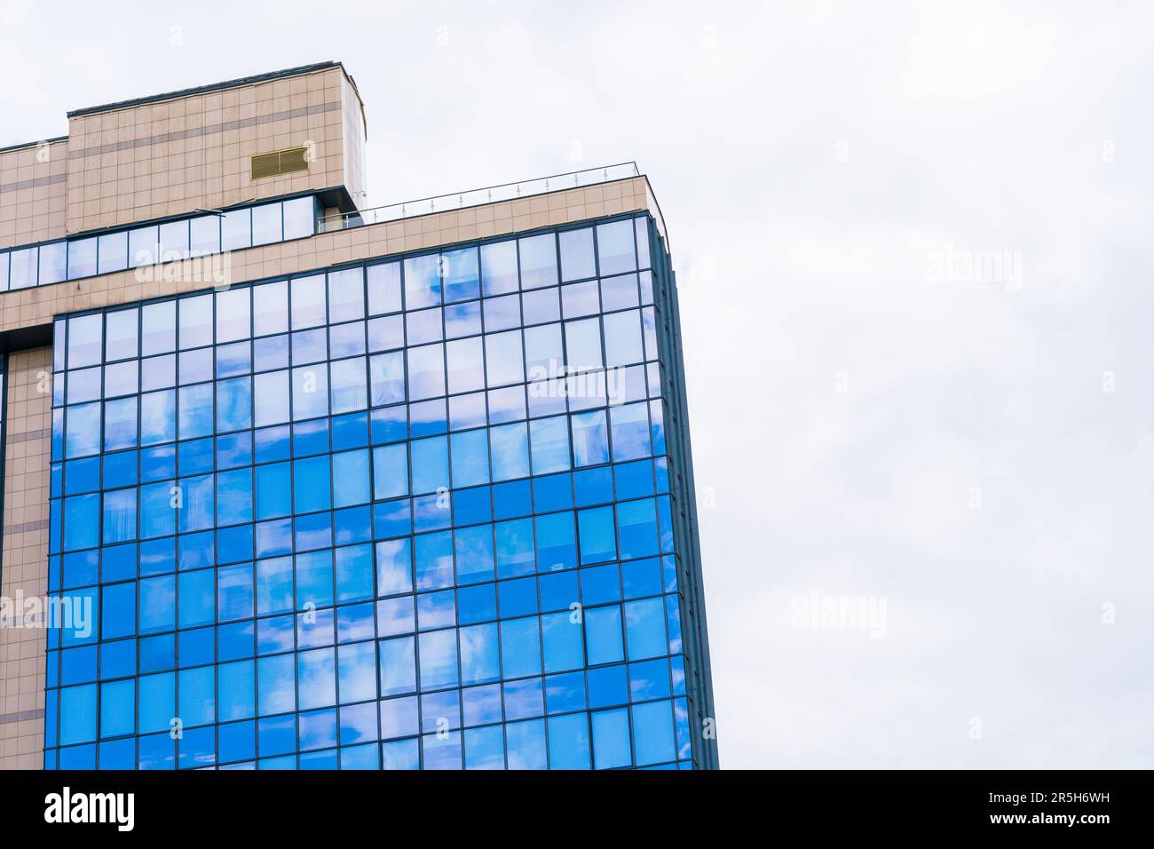 Glass Tower with a Stunning Blue windows and White Clouds reflections ...