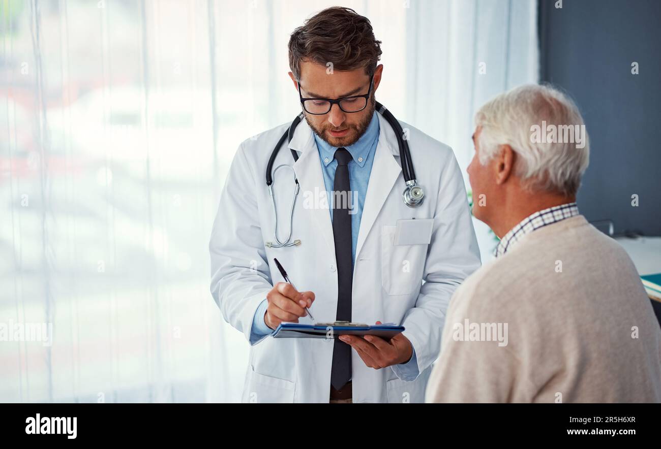 Ill make a note of that...a doctor writing notes while examining a ...