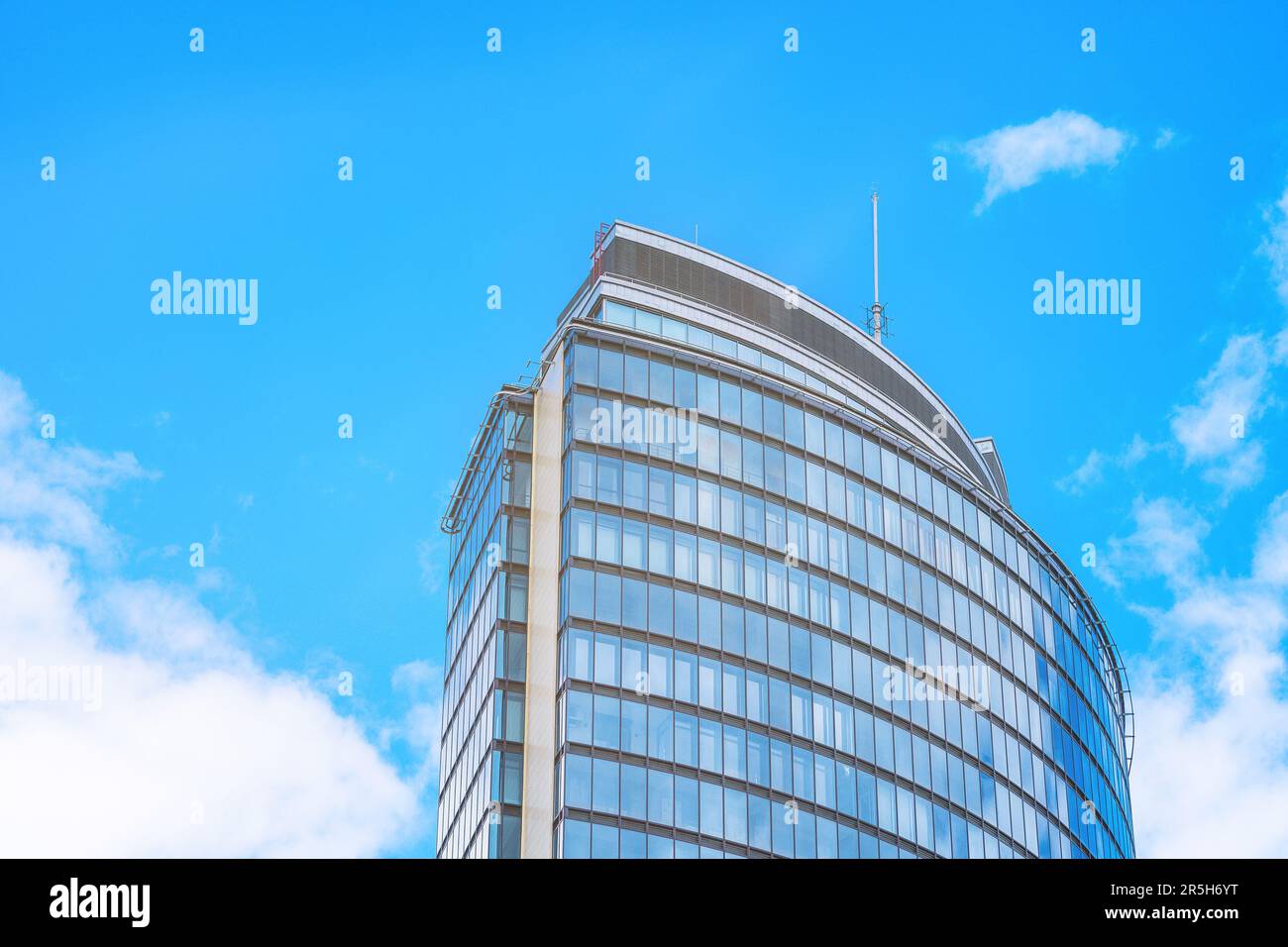 Modern Urban Glass Tower with a Stunning Blue Façade and White Clouds ...