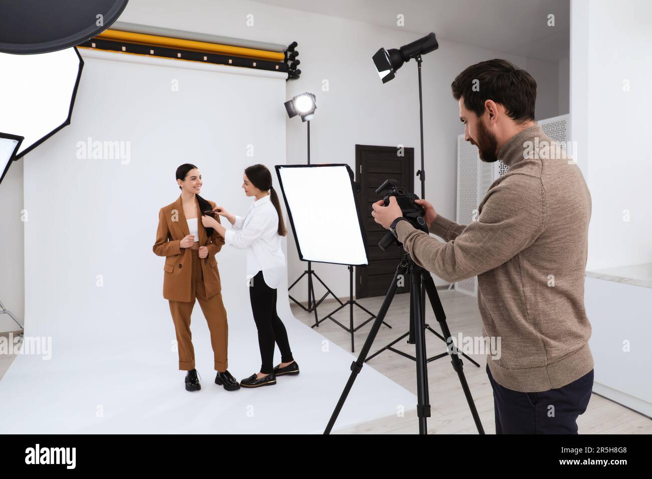 Professional photographer and stylist working with beautiful model in ...