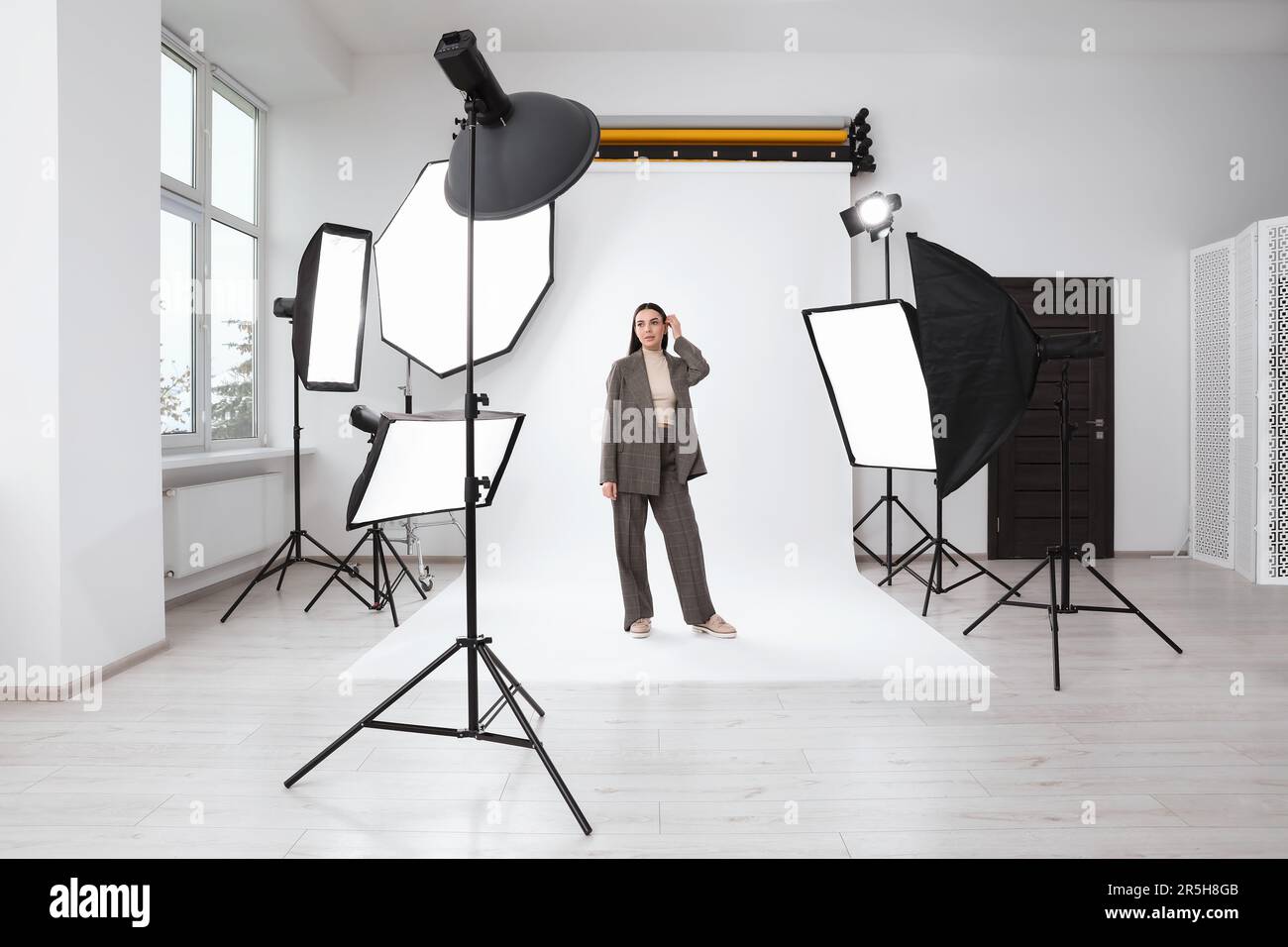 Beautiful young model posing in modern studio. Professional photo ...
