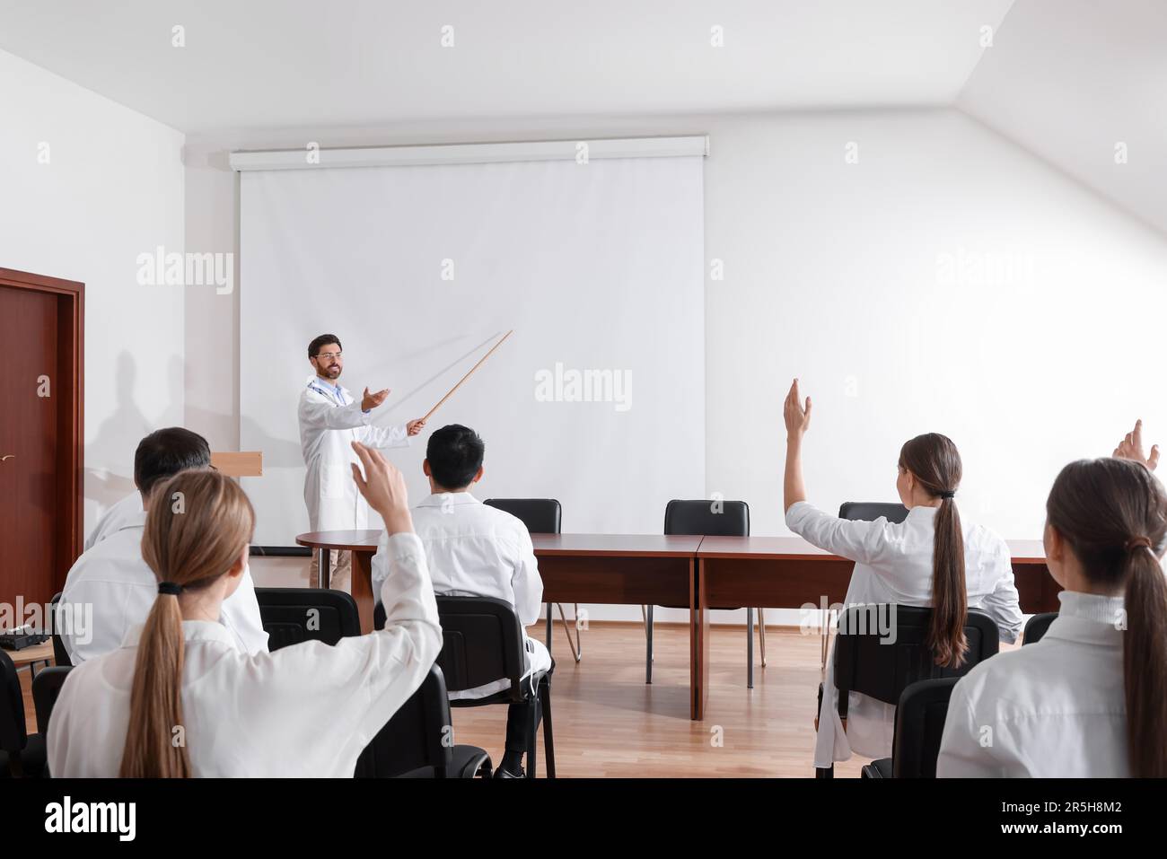 Doctor giving lecture in conference room with projection screen Stock ...