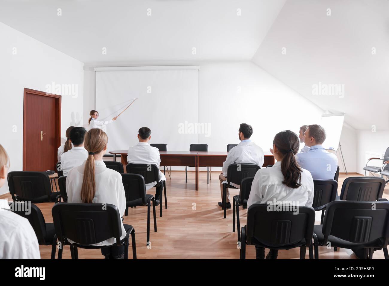 Doctor giving lecture in conference room with projection screen Stock ...