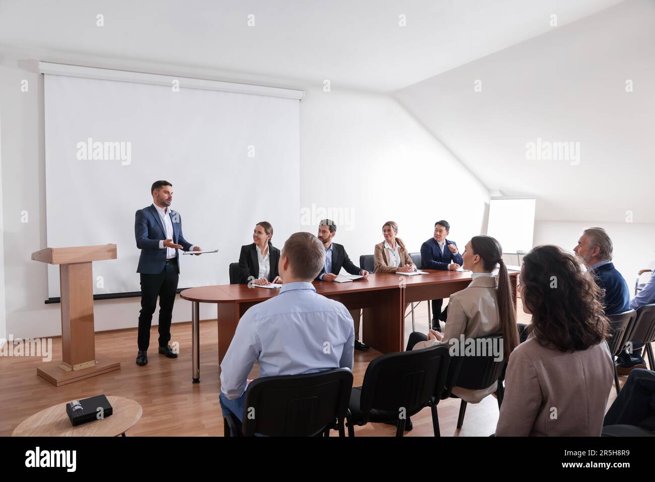 Business conference. People in meeting room listening to speaker report ...