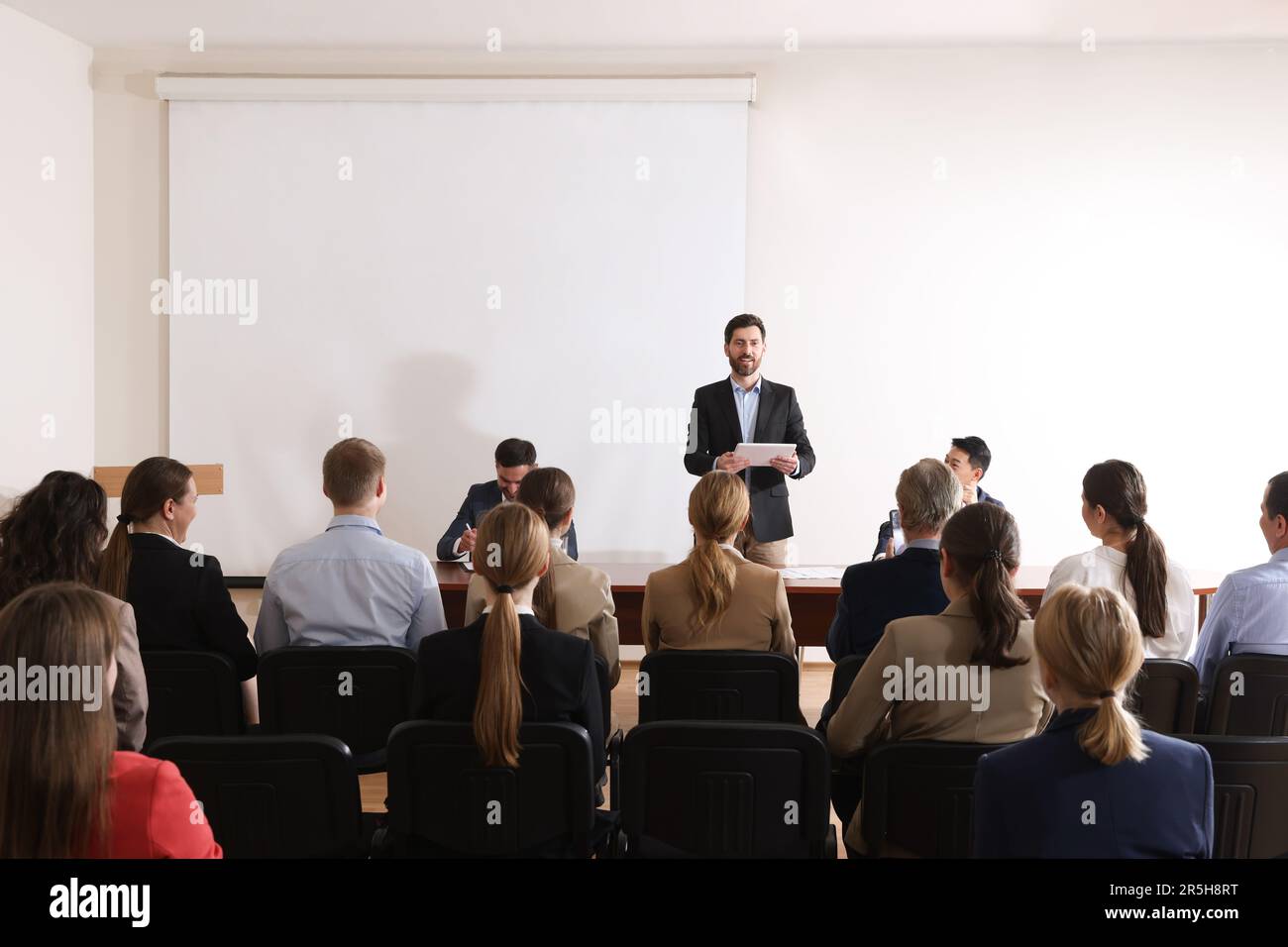 Business conference. People in meeting room listening to speaker report ...