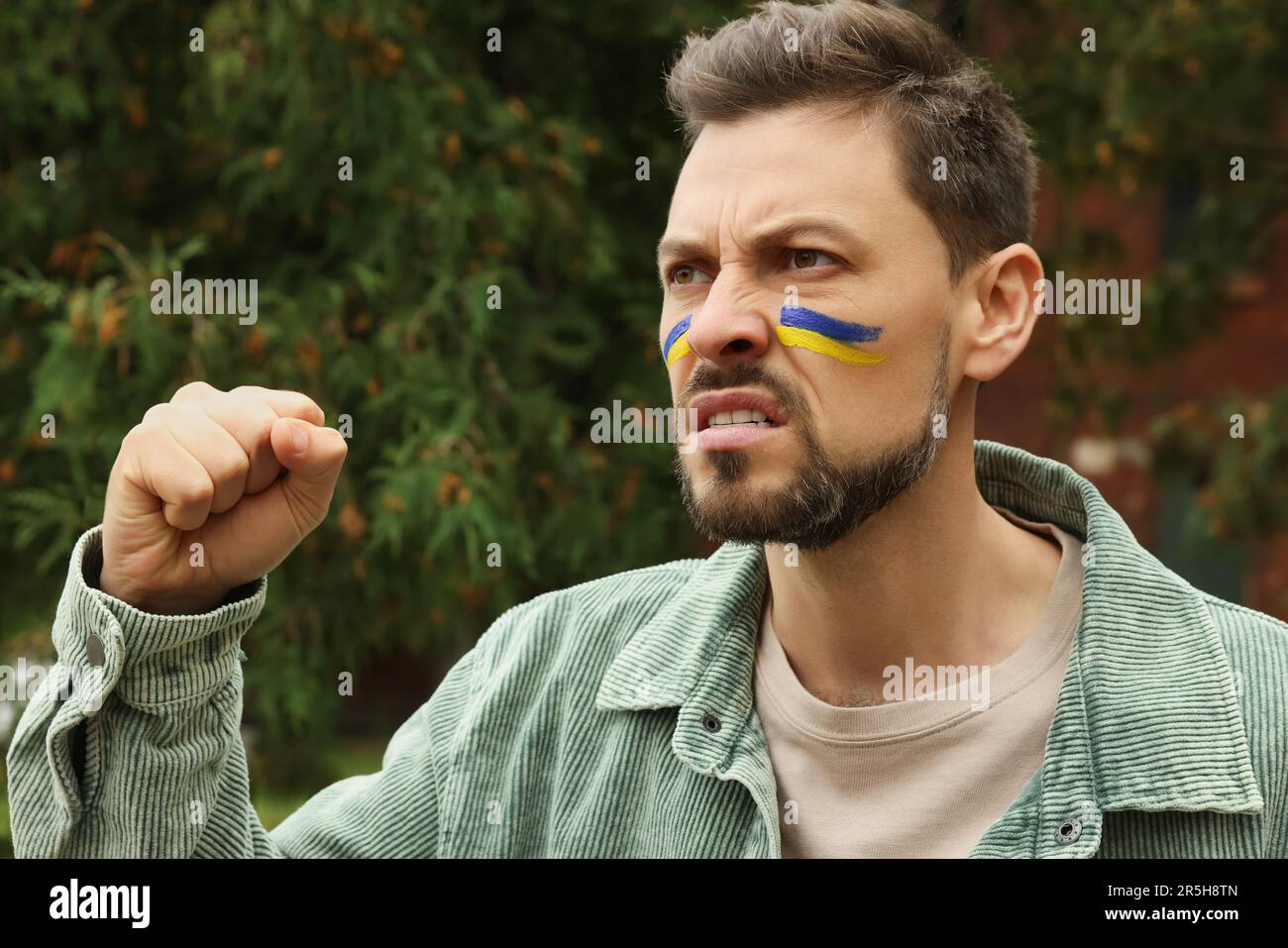 Angry man with drawings of Ukrainian flag on face outdoors Stock Photo ...