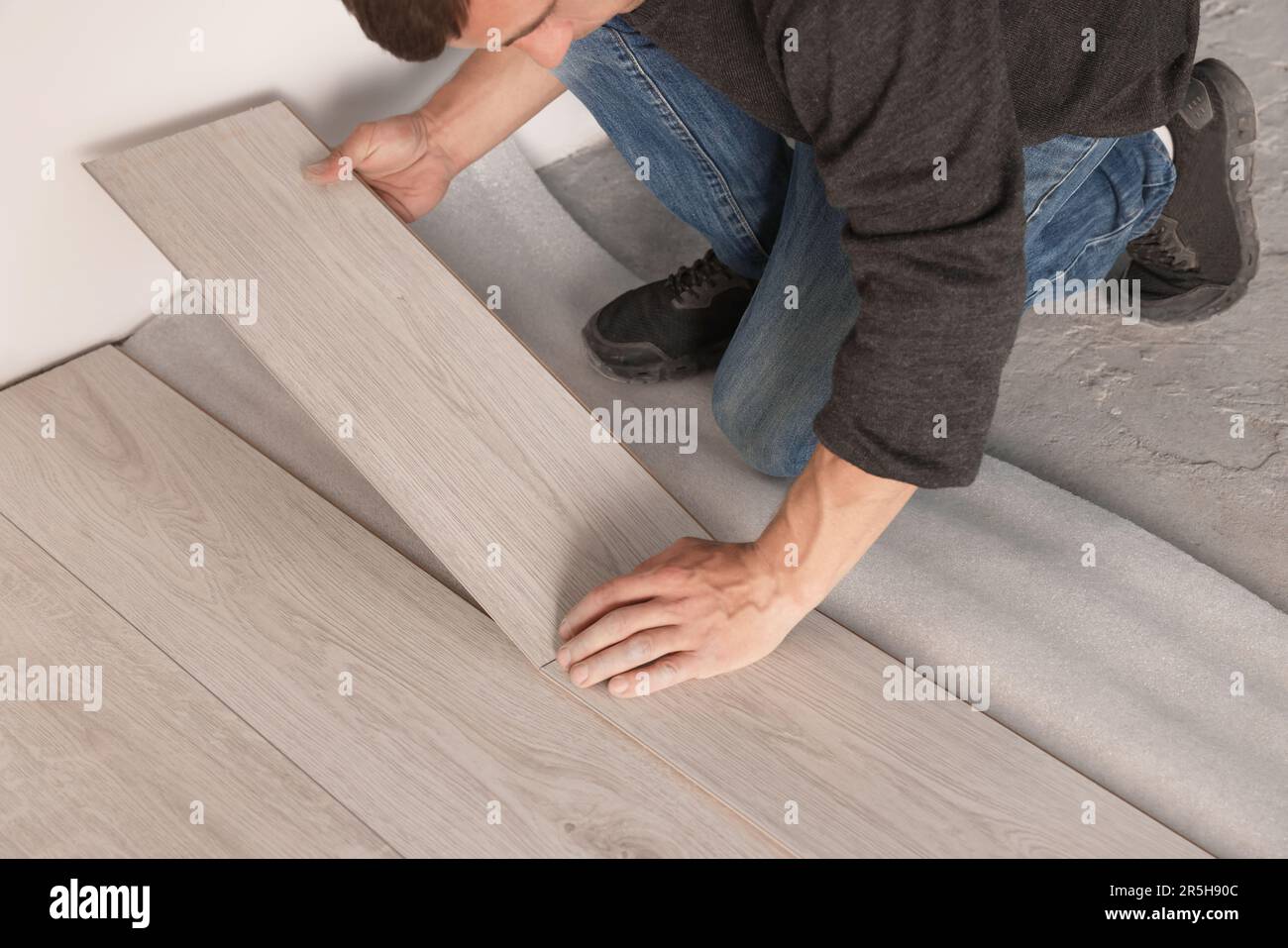 Professional worker installing new laminate flooring indoors Stock ...