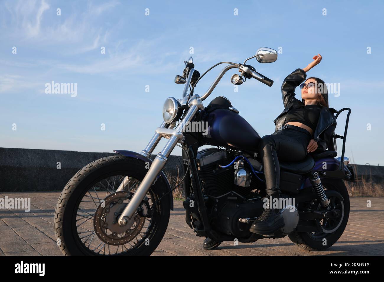 Beautiful young woman posing on motorcycle outdoors Stock Photo - Alamy