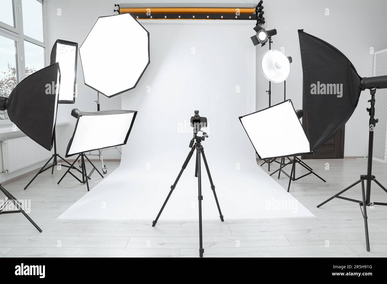 Tripod with camera and professional lighting equipment in modern photo ...