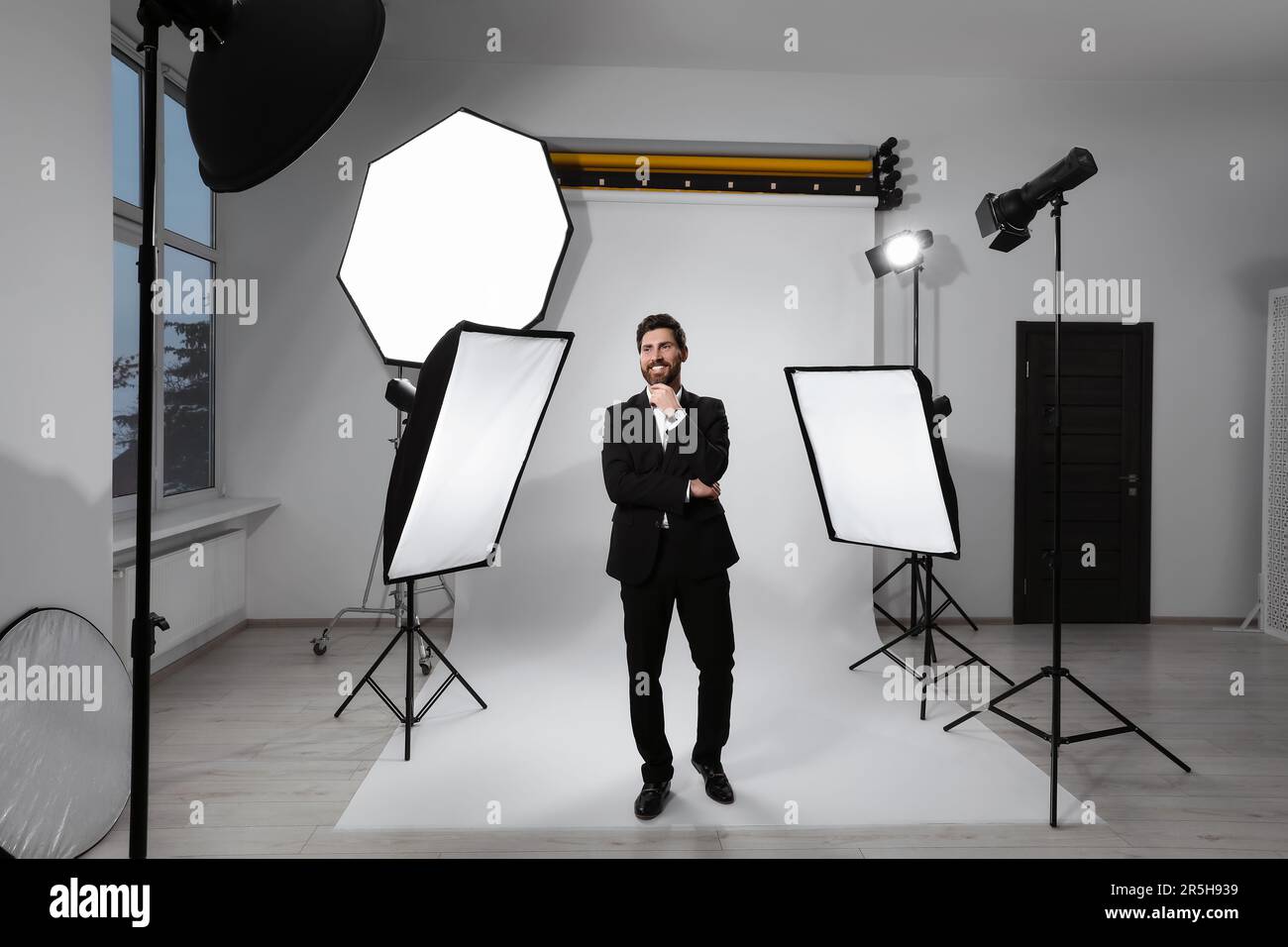 Handsome model posing in modern studio. Professional photo session ...