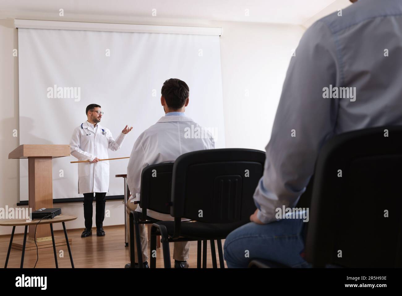 Doctor giving lecture in conference room with projection screen Stock ...