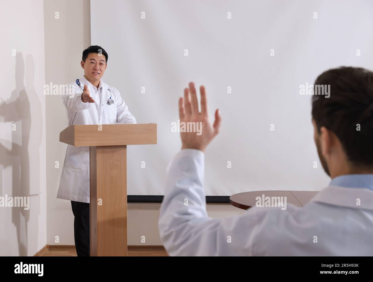 Doctor giving lecture in conference room with projection screen Stock ...