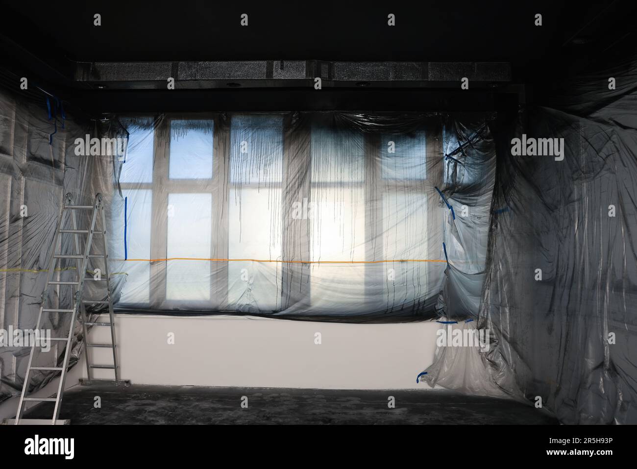 Windows and wall covered with polyethylene film. Protection during ...