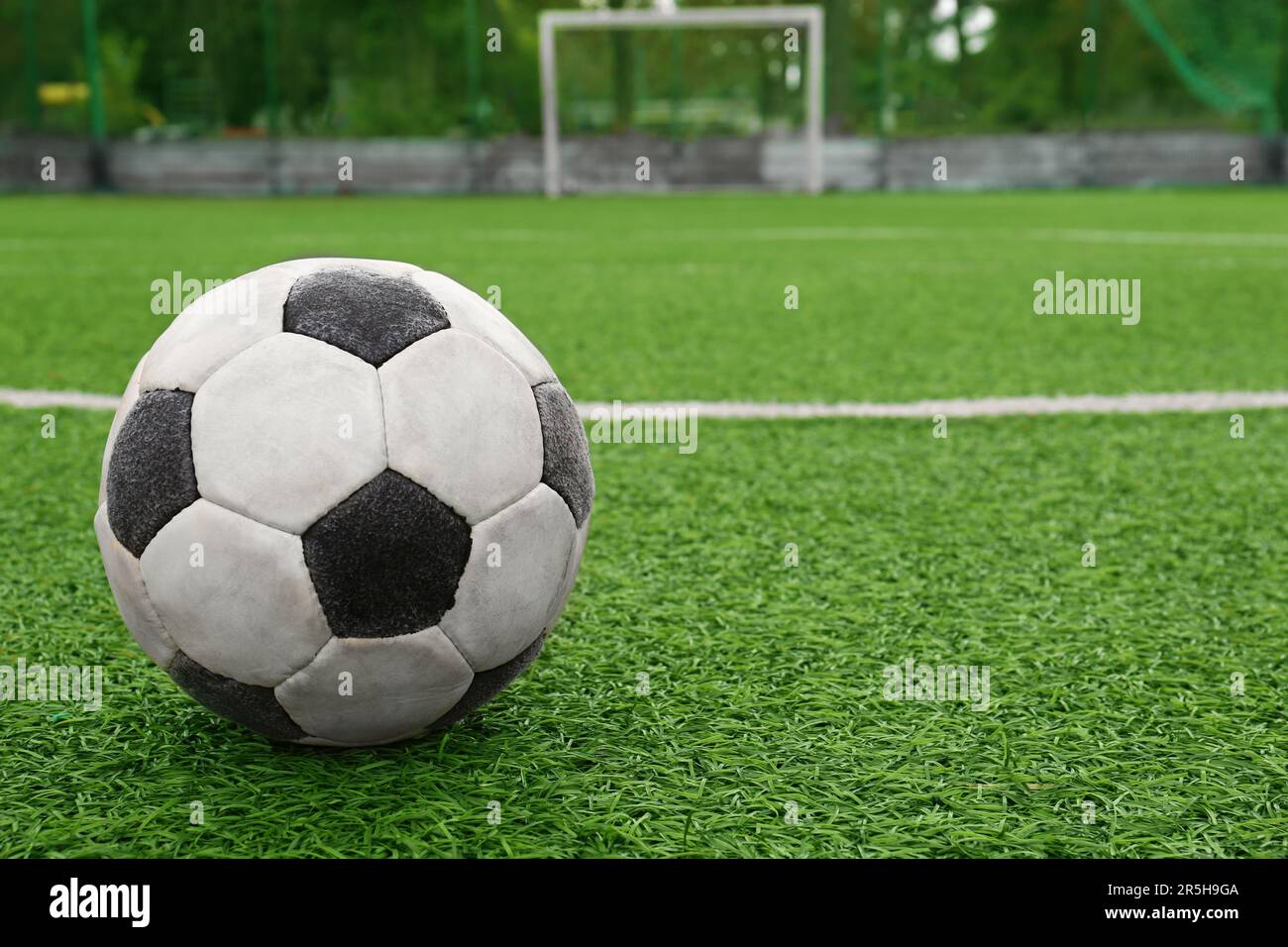 Dirty soccer ball on green football field, space for text Stock Photo ...