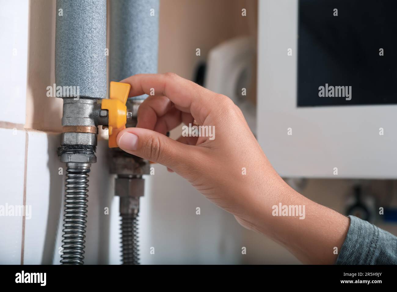 Woman turning on valve hi-res stock photography and images - Alamy