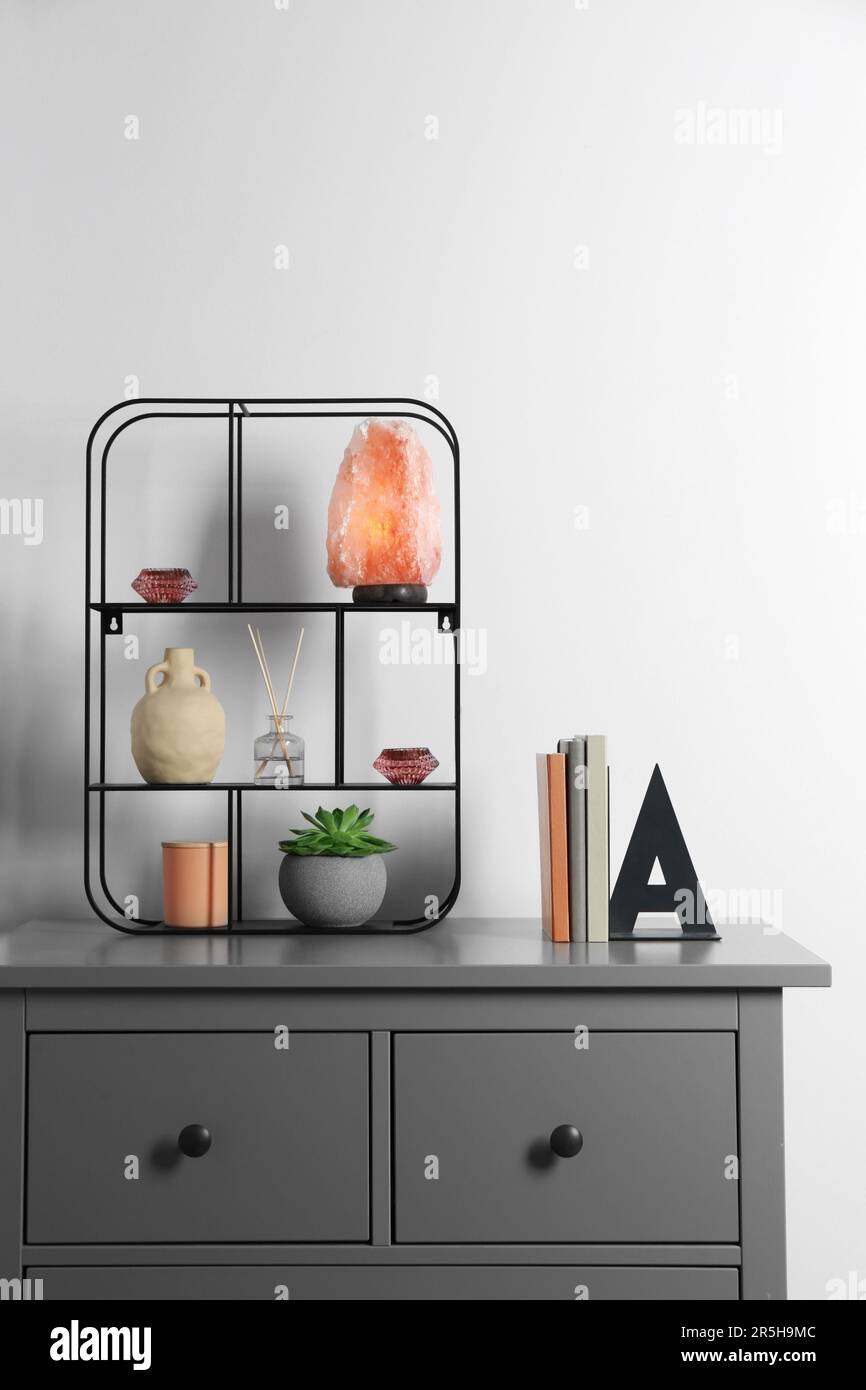 Shelving unit with decorative elements and books on chest of drawers ...